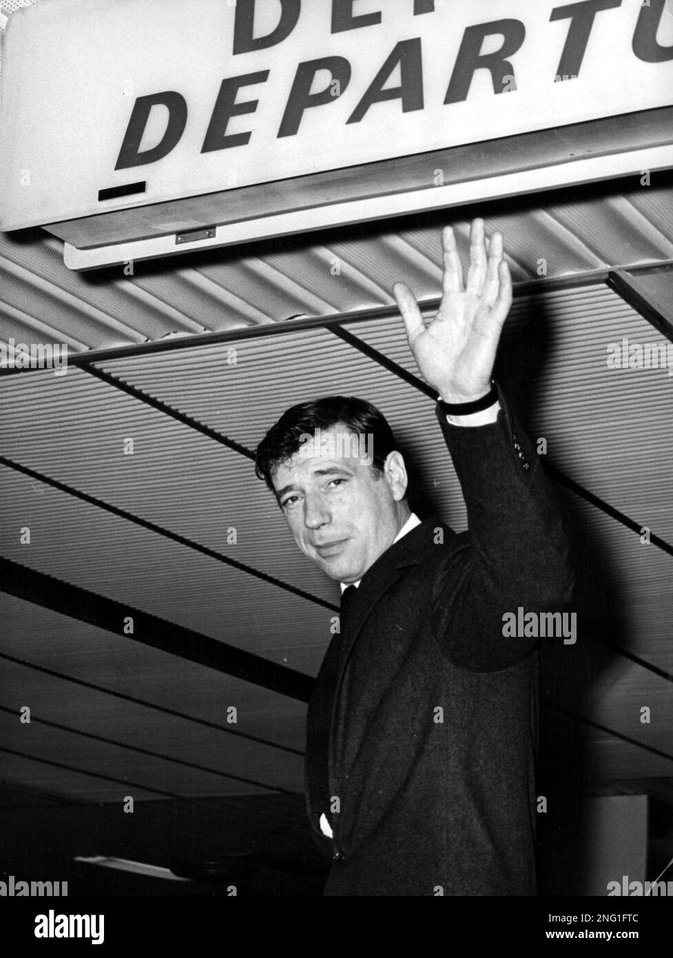 French actor and singer Yves Montand, waves at Orly airport in Paris at ...