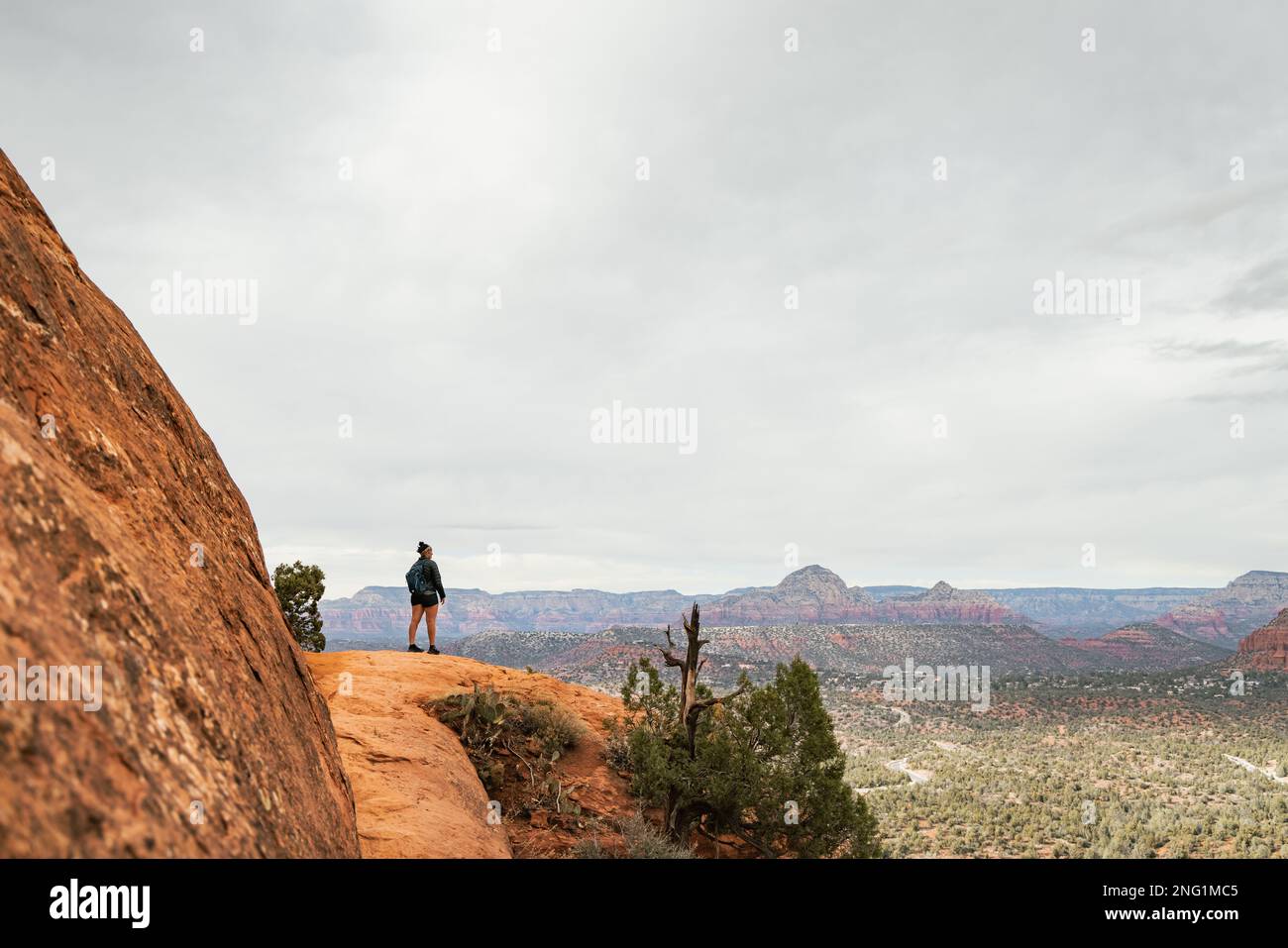 Woman hiker standing on Bell Rock trail in red rock formations within ...