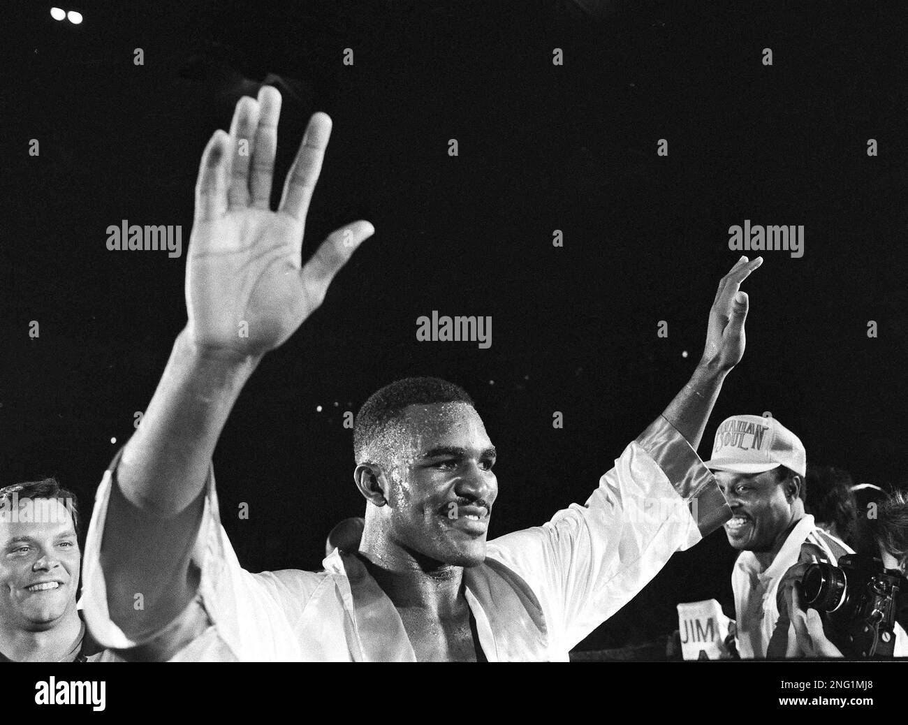 Junior heavyweight boxer Evander Holyfield raises his hands in victory ...