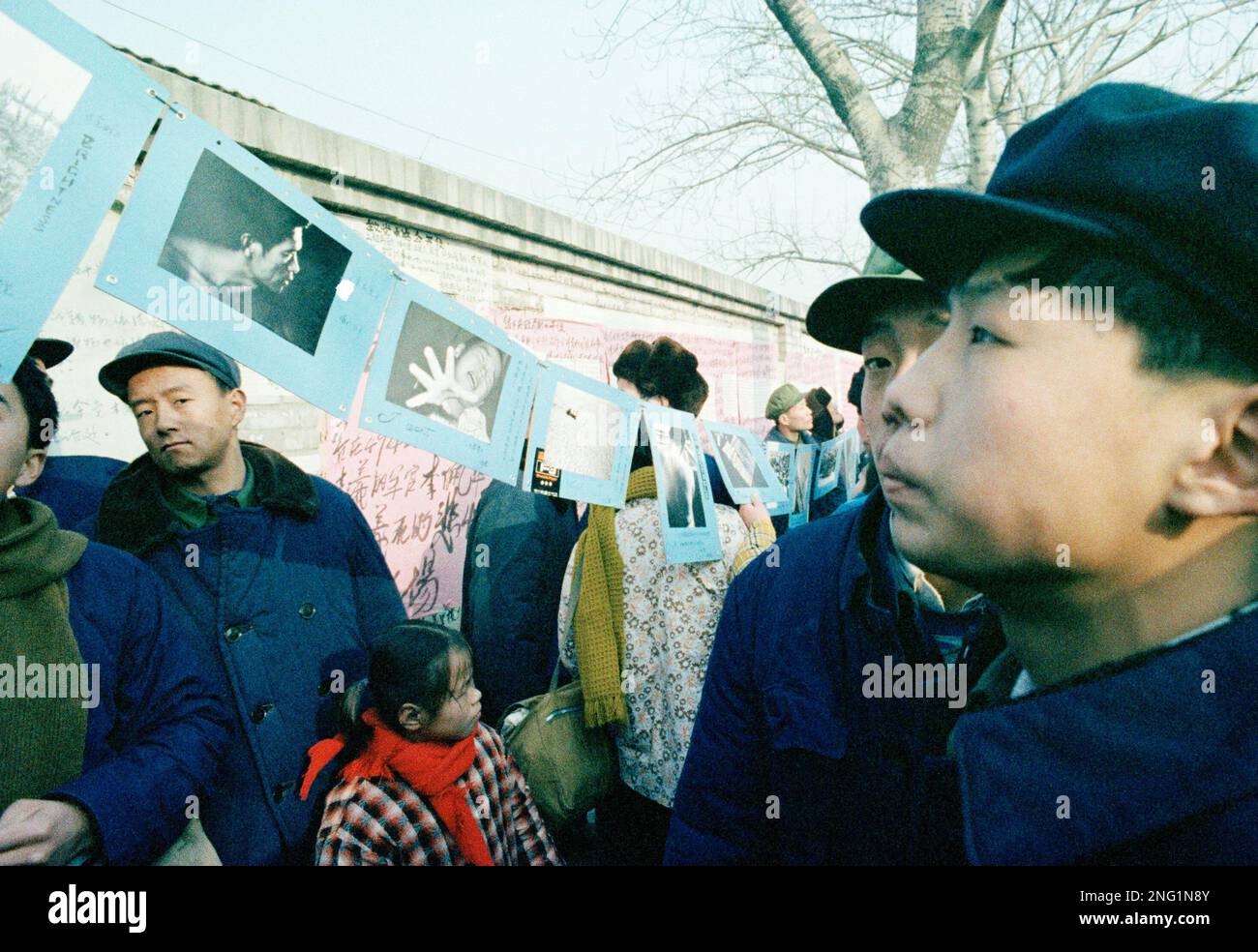 Chinese passers-by view an exhibition of art photos with a message at ...