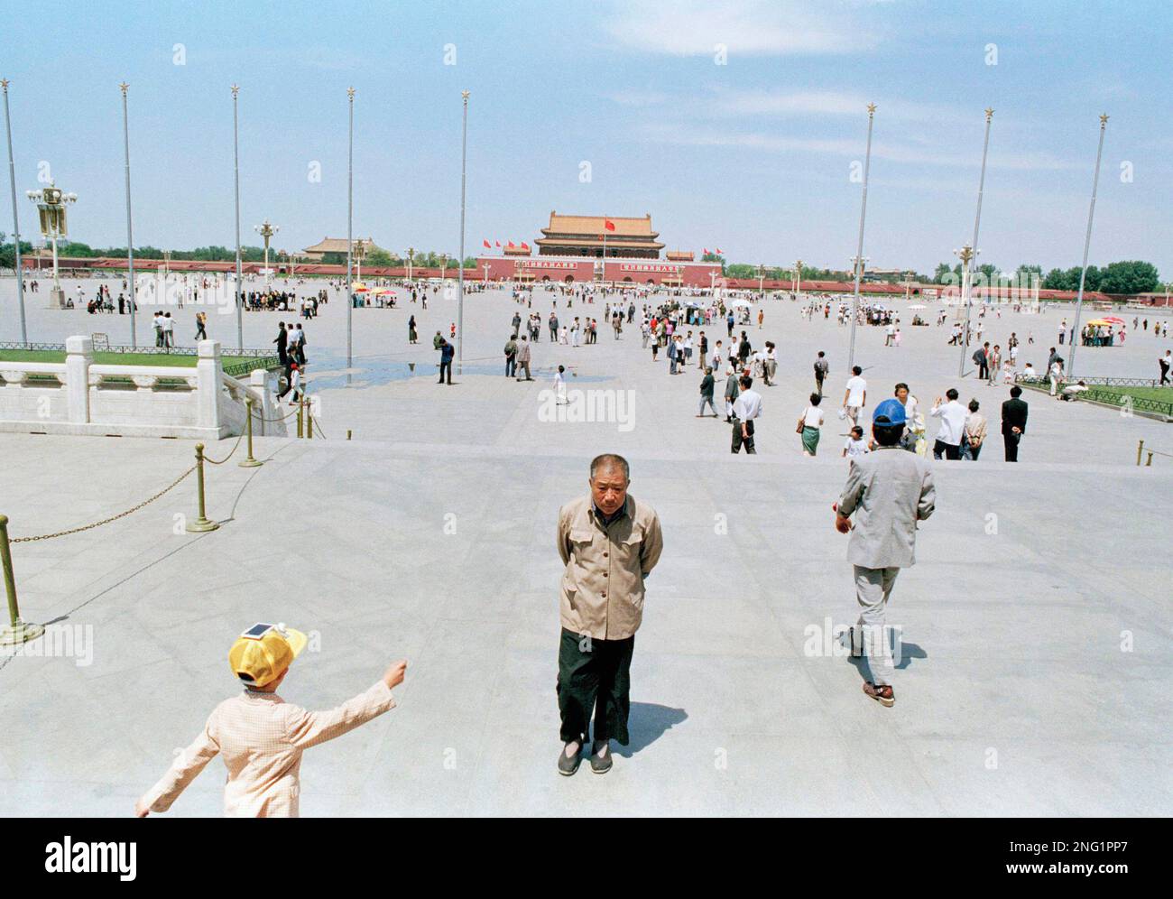Chinese people, young and old, stroll in the sprawling Tiananmen Square ...