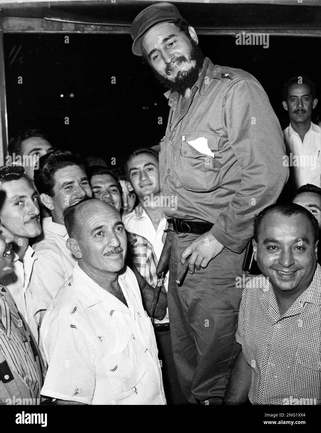 Cuban leader Fidel Castro stands on a table during a trip to a village ...