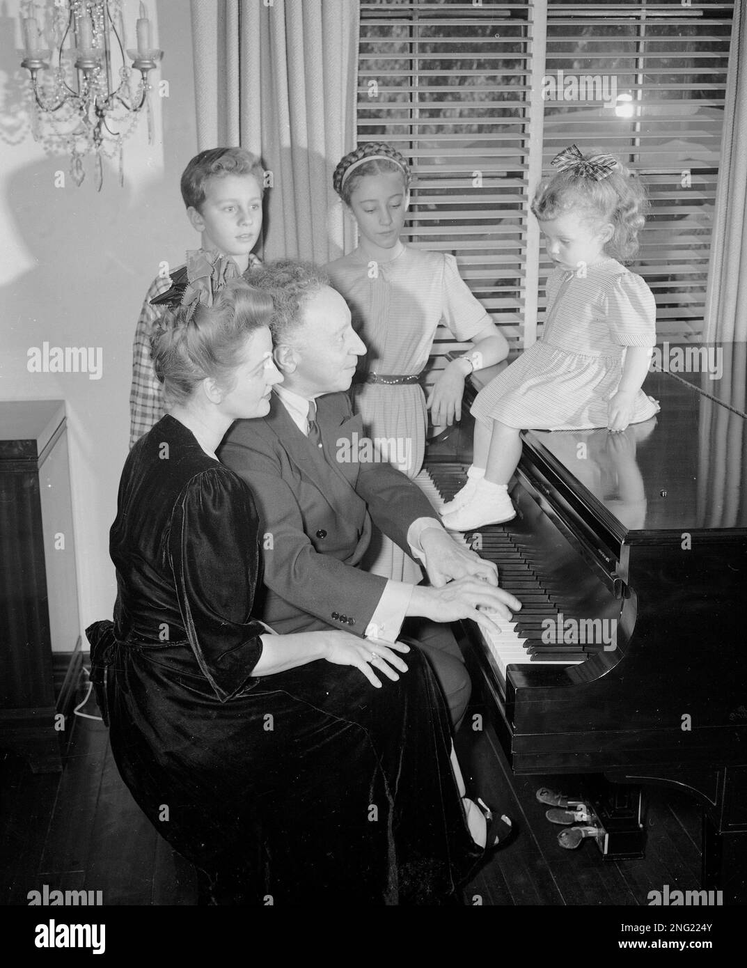 Pianist Arthur Rubinstein is shown seated at piano beside his wife ...