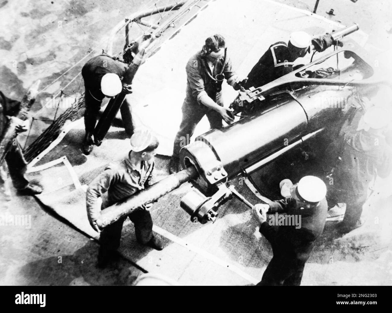 American sailors loading a gun to fire on a German submarine during ...