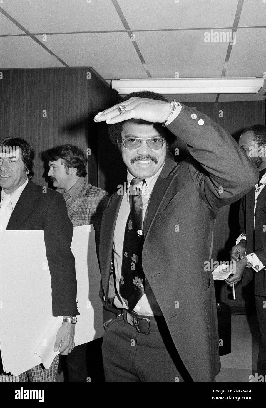 Reggie Jackson shades his eyes from television lights as he looks for ...