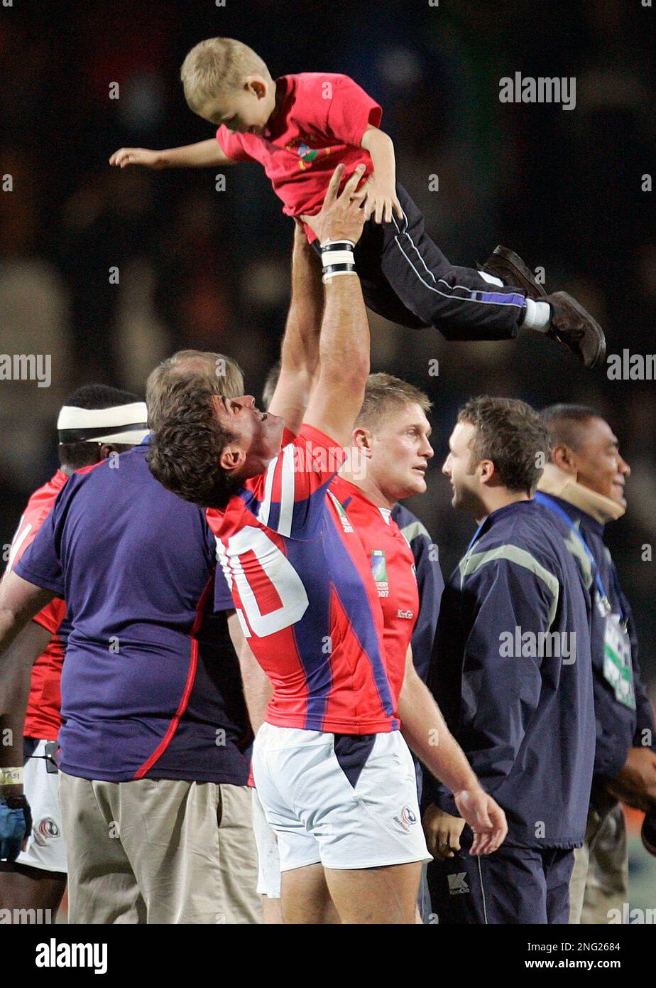 United States' Mike Petri lifts an unidentified child into the air ...