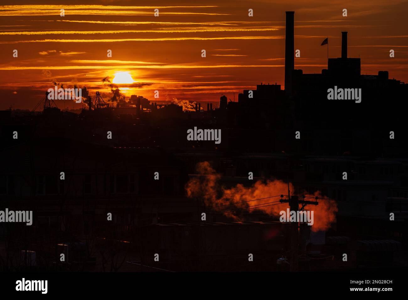 A low-angle shot of a factory with smoke billowing out of its chimneys ...