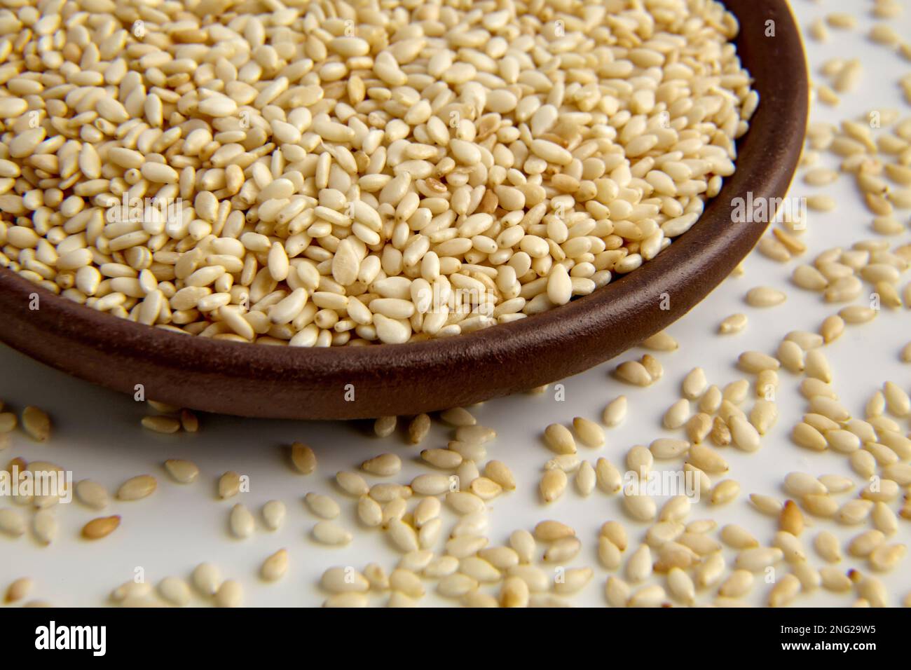 White roasted sesame in clay ceramic bowl closeup isolated on white ...