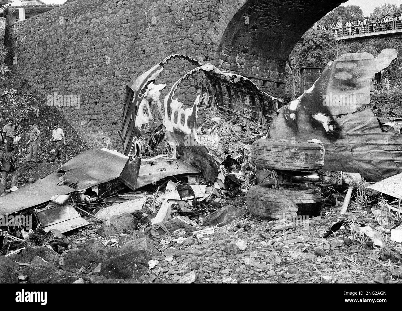 Spectators, upper right, crowd in for a look at the wreckage of a ...