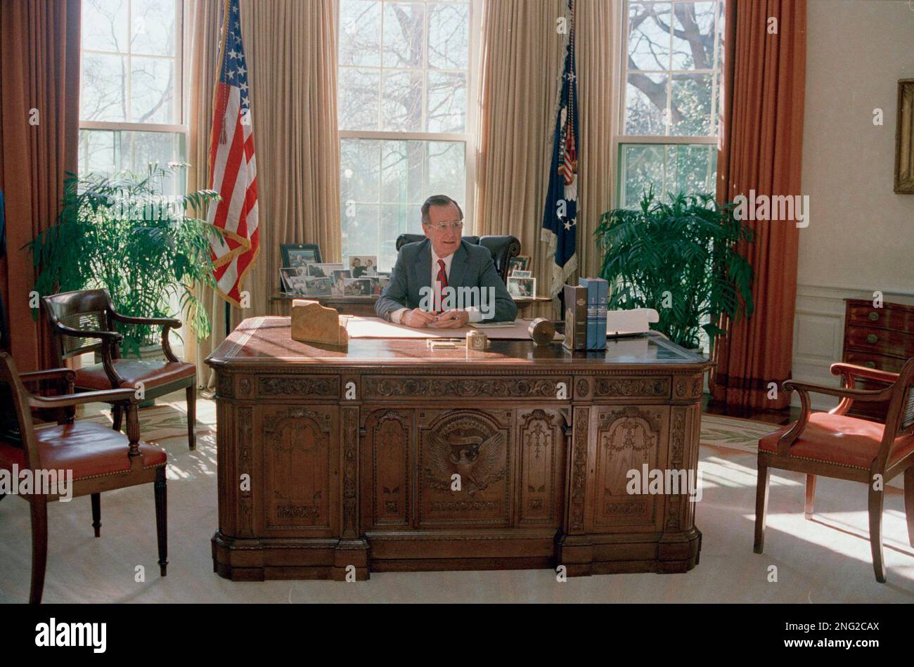 President George Bush is seen at work behind his desk in the Oval ...