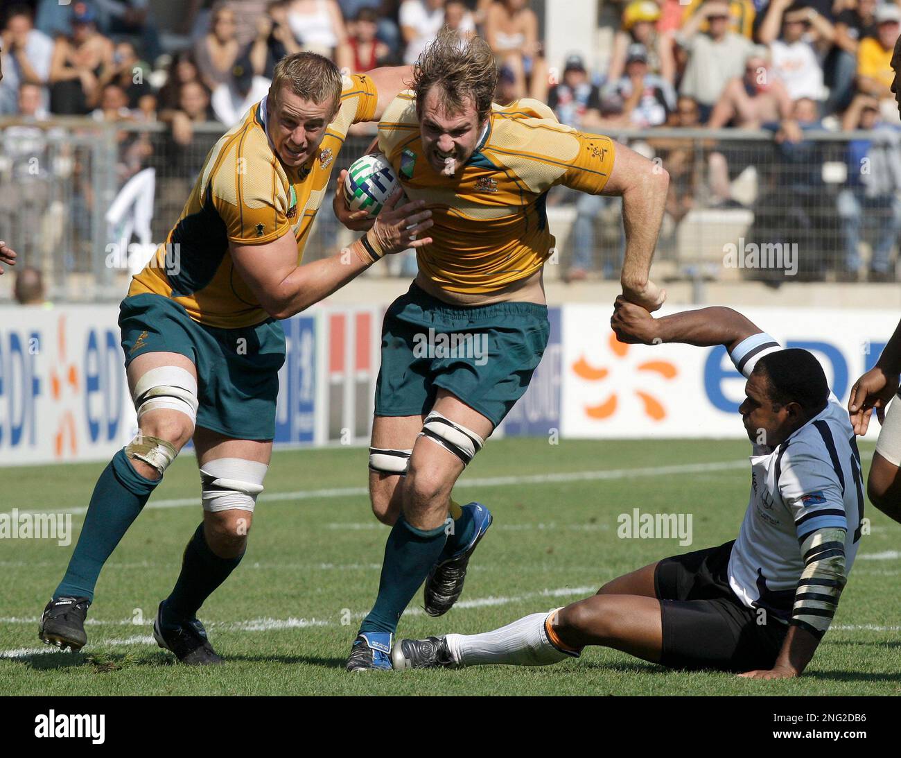 Australia's Rocky Elsom, center, and Mark Chisholm, left, go on the ...