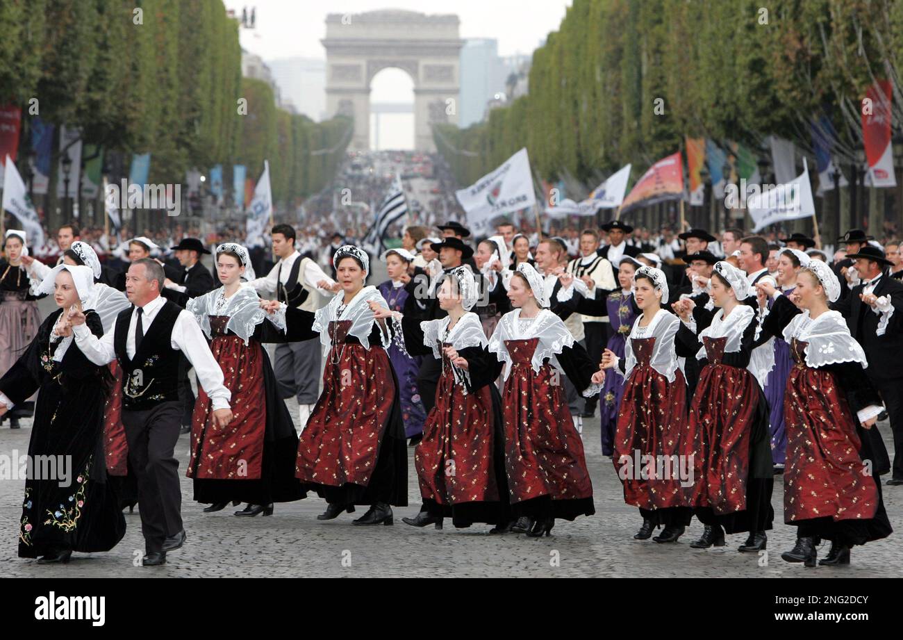 Breton dancers wearing folk costumes walk down the Champs Elysees, as ...