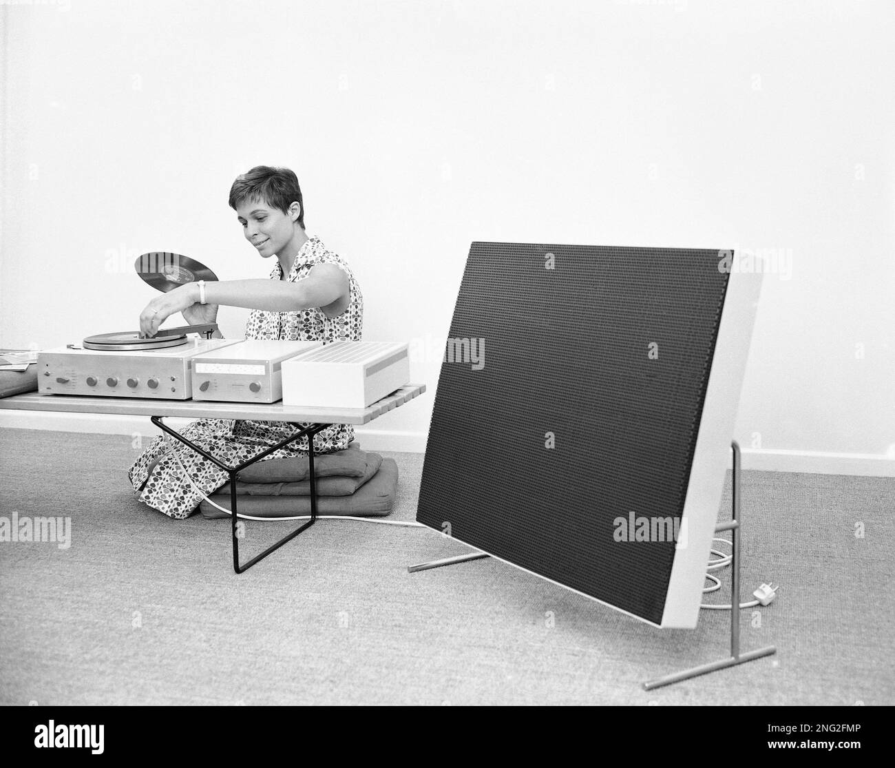 A young woman demonstrates a new type of loudspeaker, right, shown at ...