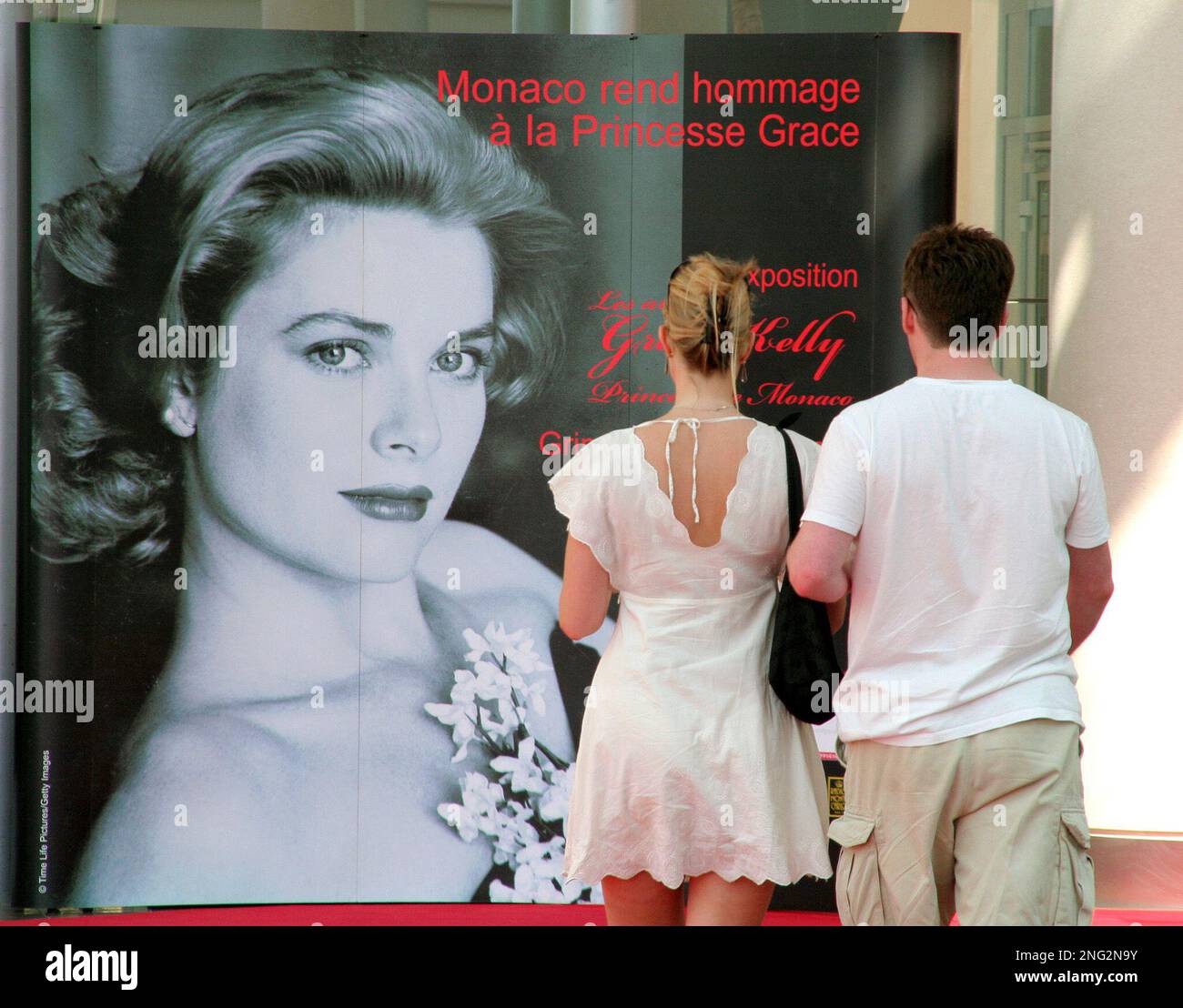 Visitors Look At A Poster Of Princess Grace Of Monaco During The Exhibition In Homage To