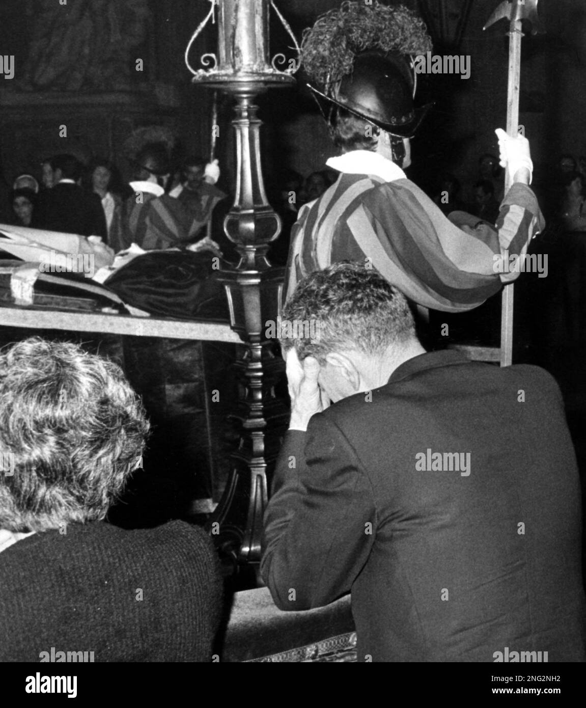 Edoardo Luciani kneels in prayer in front of the body of his brother ...
