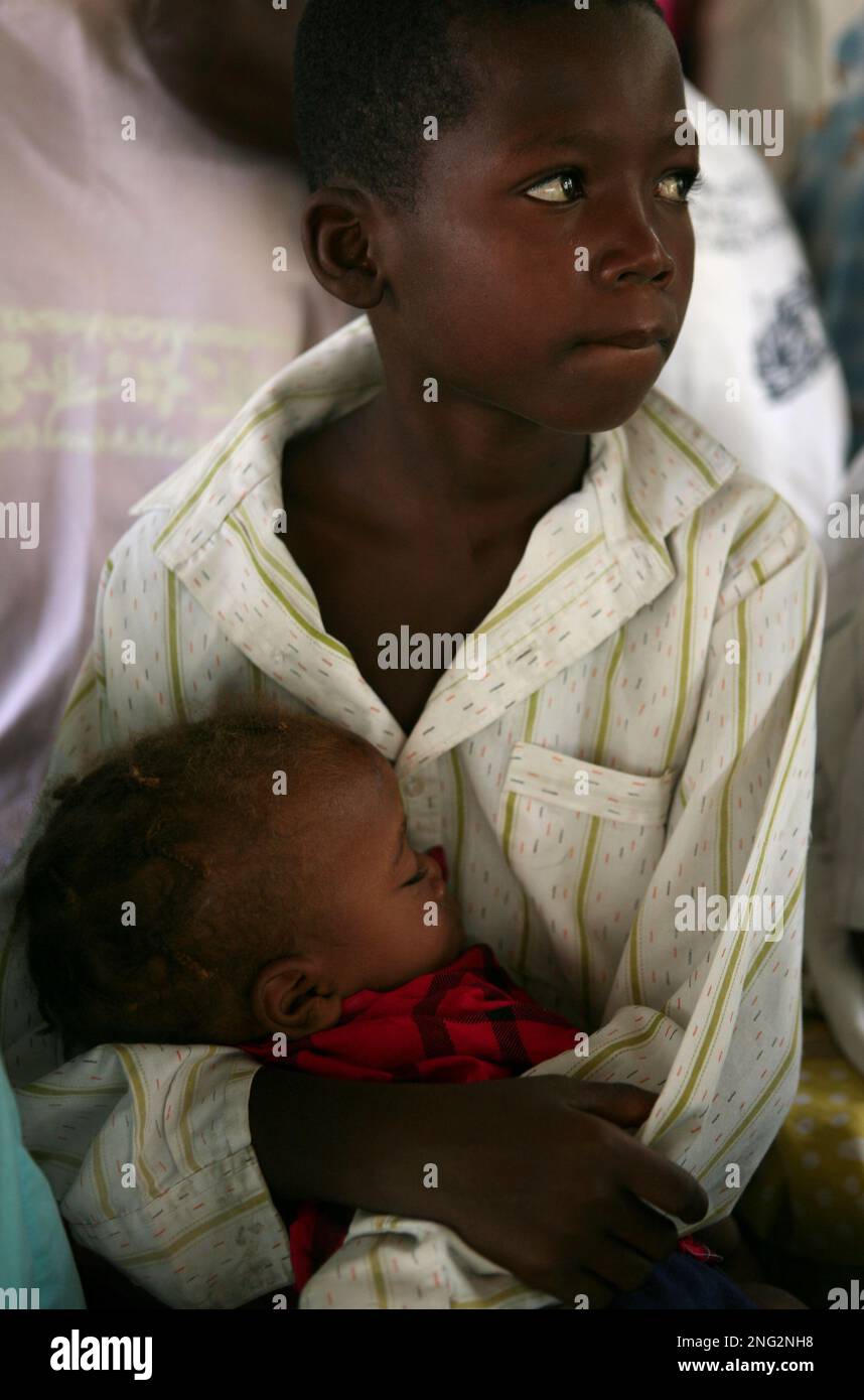Jeason, 8, holds his little brother as they wait to be vaccinated at ...