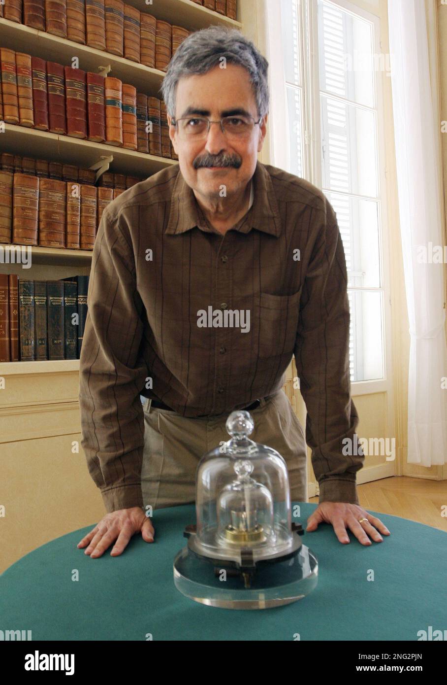 Physicist Richard Davis of the International Bureau of Weights and Measures stands next to a ...