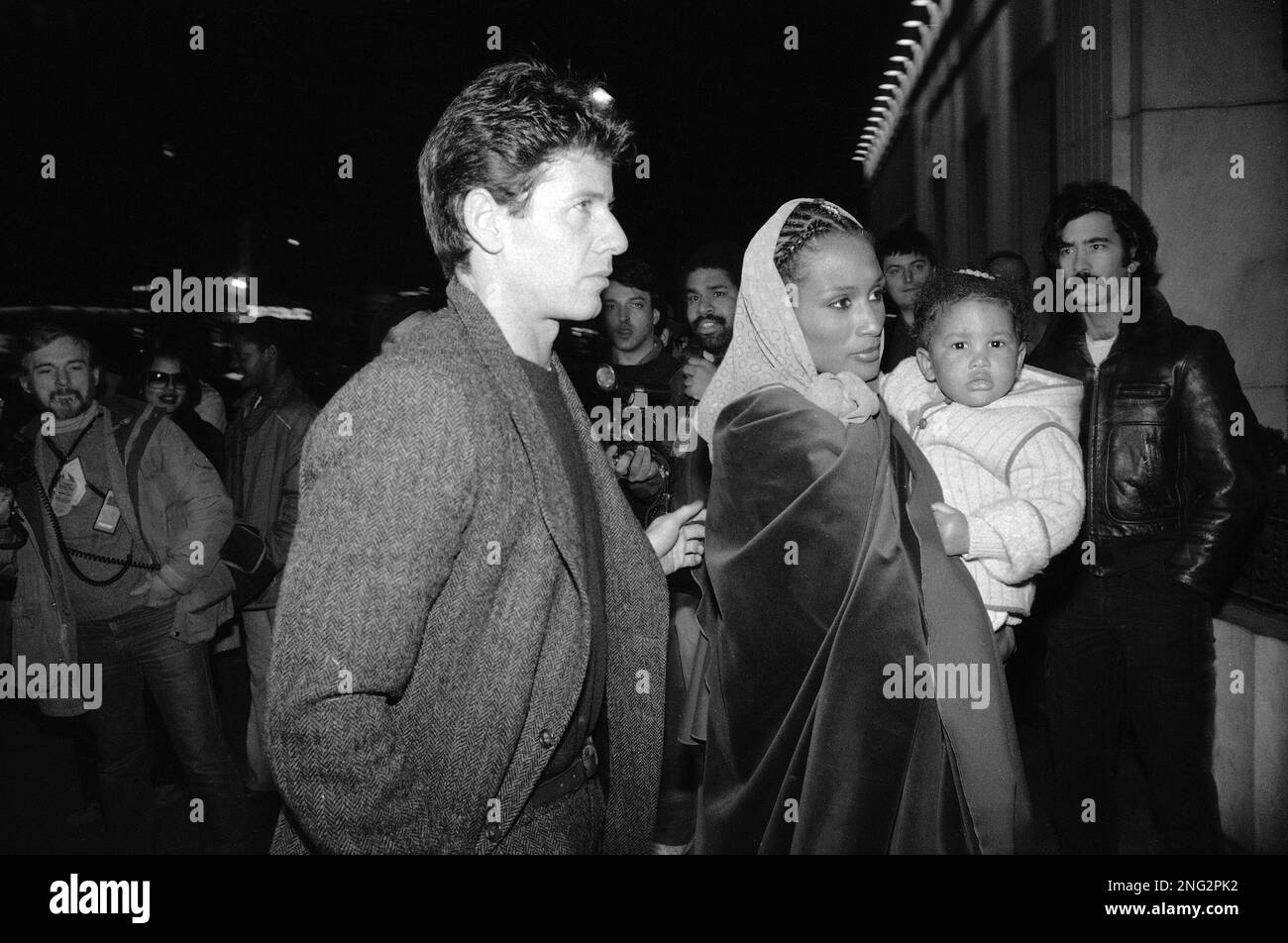 Fashion designer Calvin Klein and model Iman, carrying her young ...