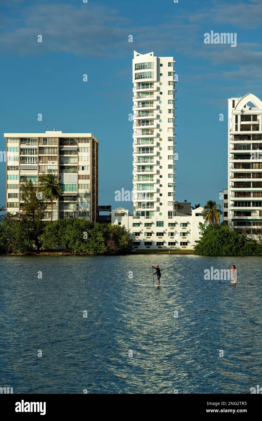 Paddle boarders on El Condado Lagoon and skyline, El Condado, San Juan ...