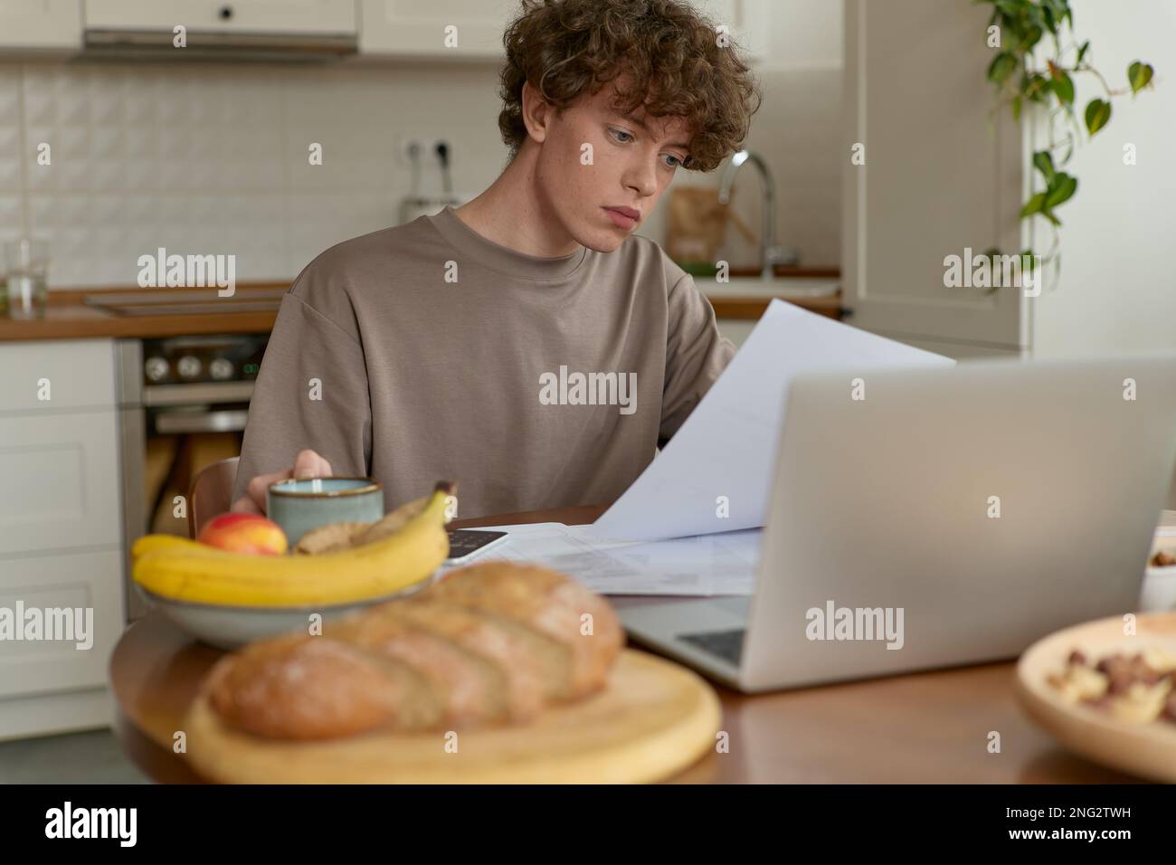 Portrait of a young curly haired casual-dressed male student having a ...