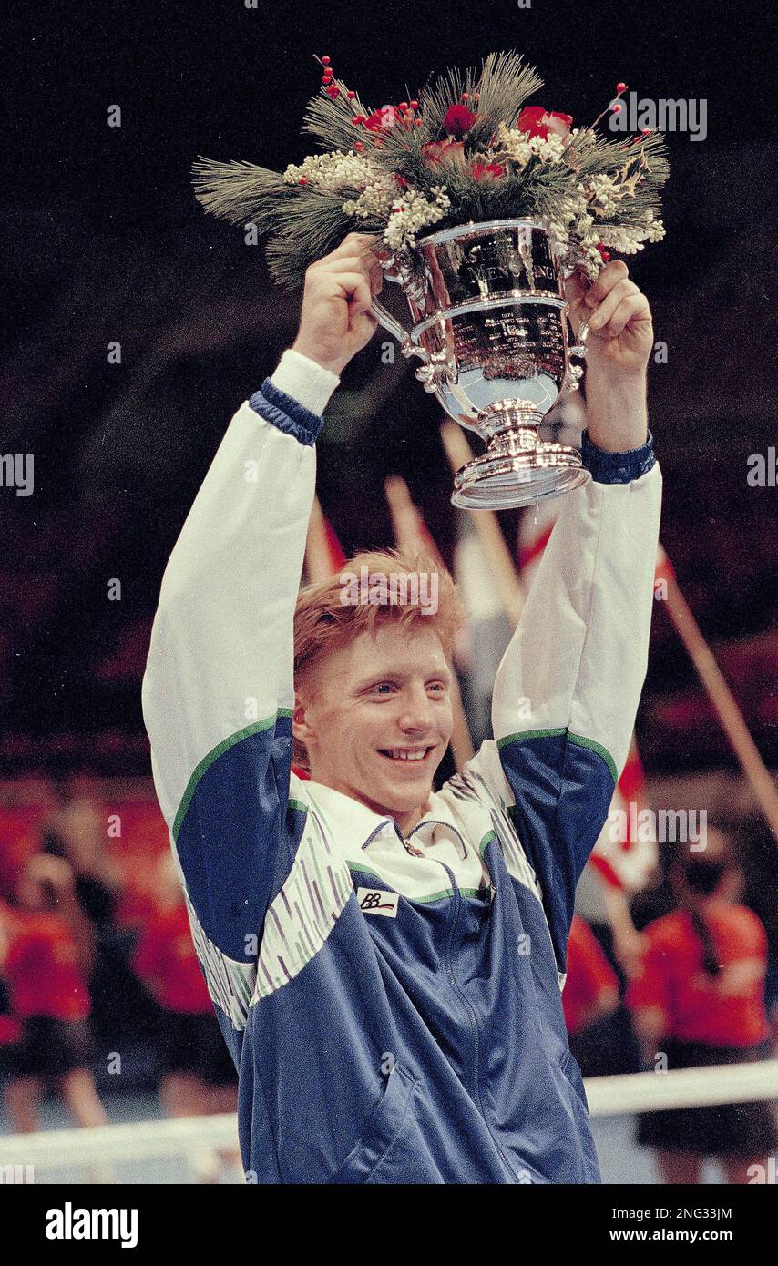 German tennis star Boris Becker holds up the trophy after winning the ...
