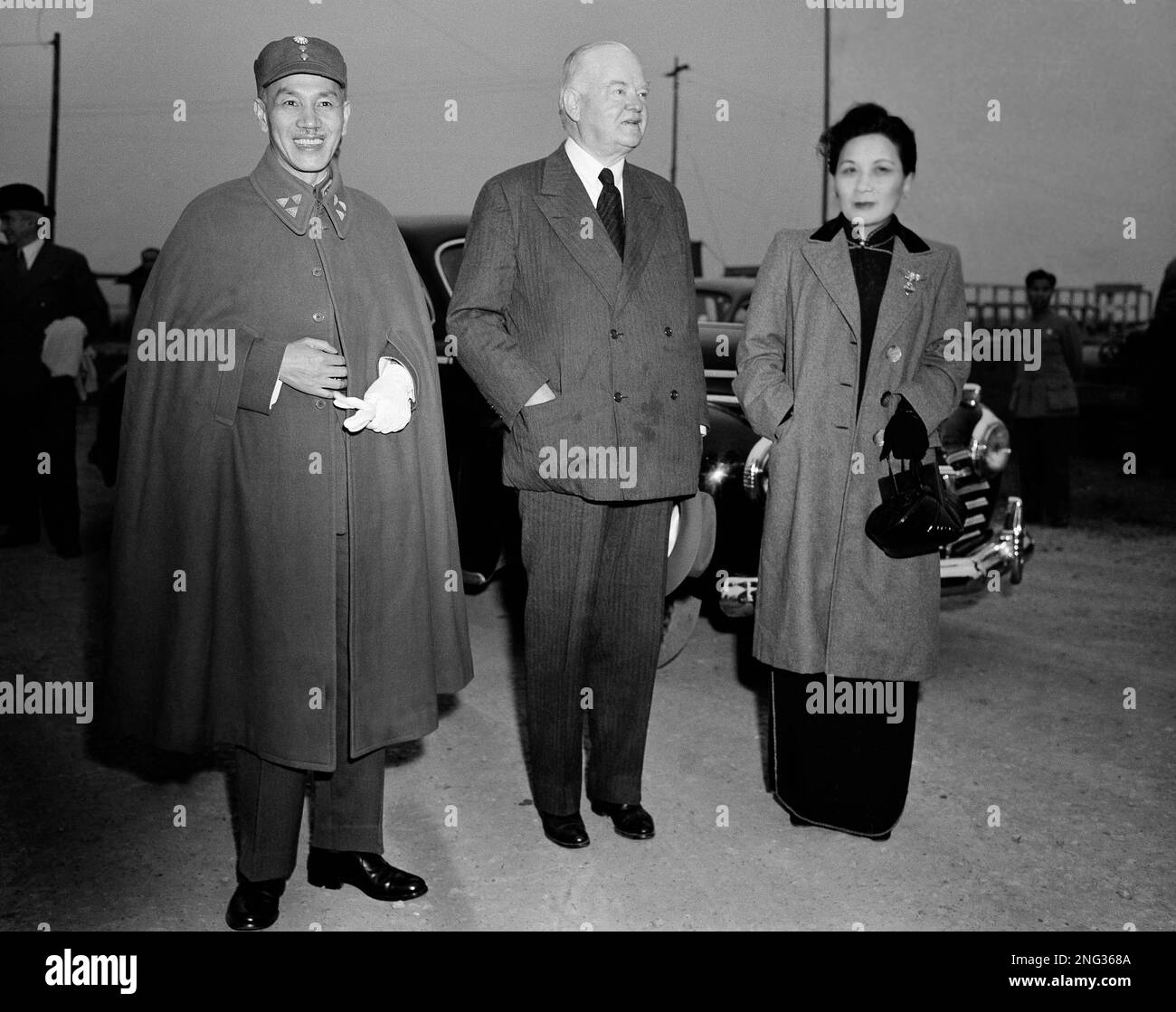 Herbert Hoover, center, walks to his plane with Generalissimo and ...