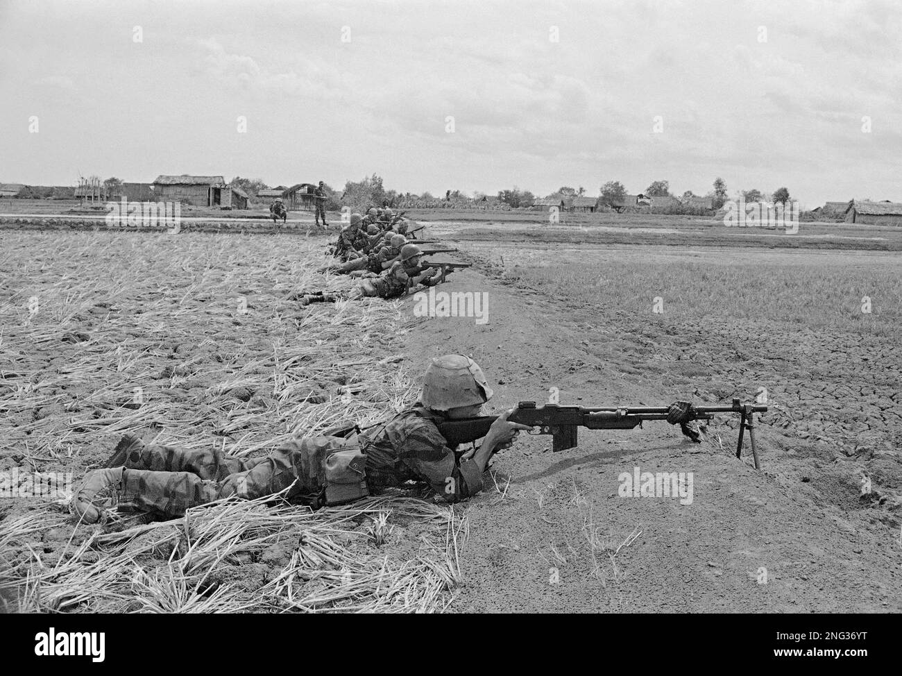 Vietnamese Marines fire from positions behind dike of dried out rice paddy during engagement ...