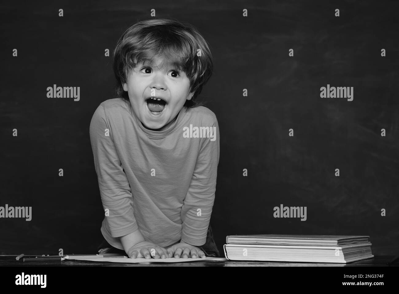 Kid is learning in class on background of blackboard. Happy school kids ...