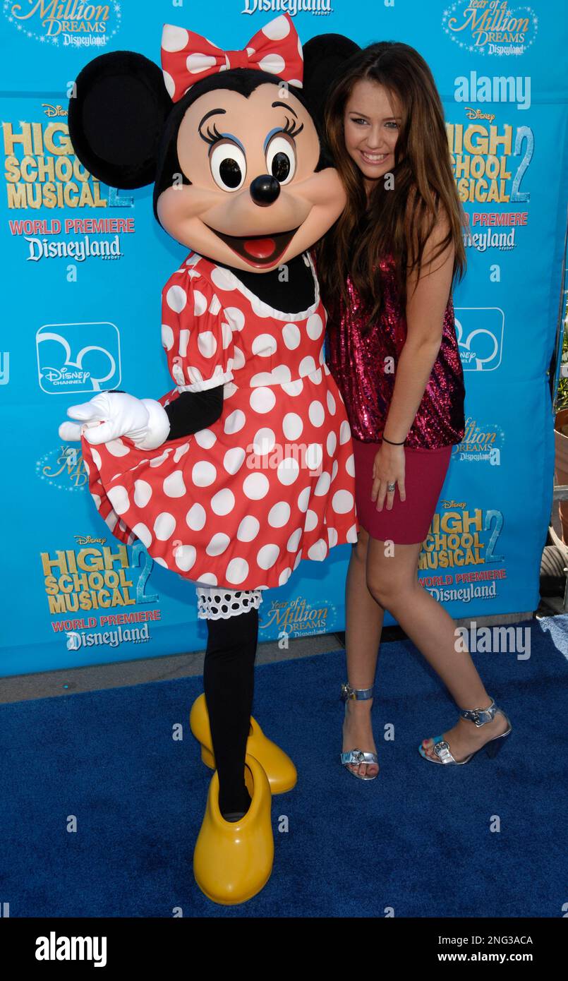 Actress Miley Cyrus, right, is seen with character Minnie Mouse during ...