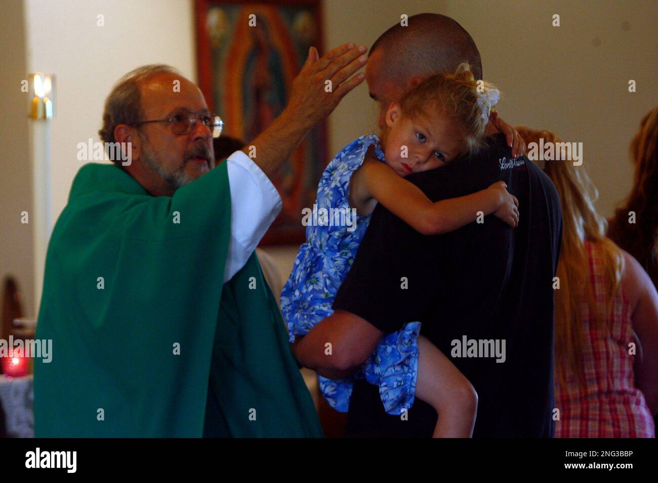 Father Donald Hope blesses a parishioner after giving the holy ...
