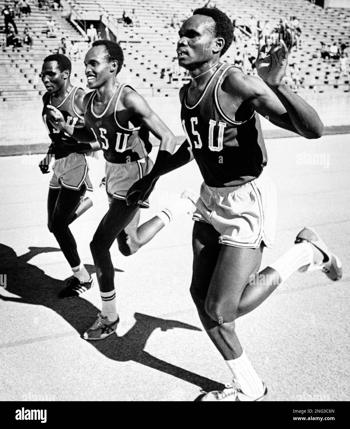 Kenyan distance runner Henry Rono, right, takes a victory lap with ...