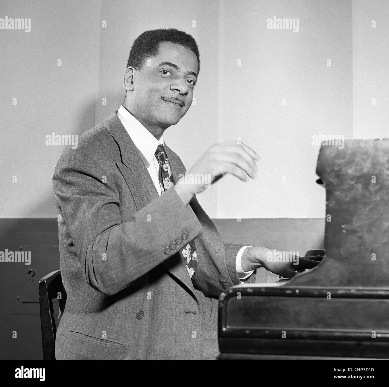 Jazz pianist Teddy Wilson seated at a grand piano in a studio room ...