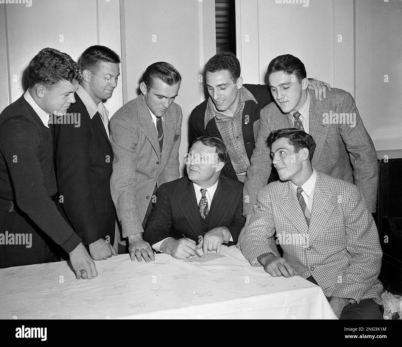Coach Wallace Butts, seated at center, goes over strategy with his ...