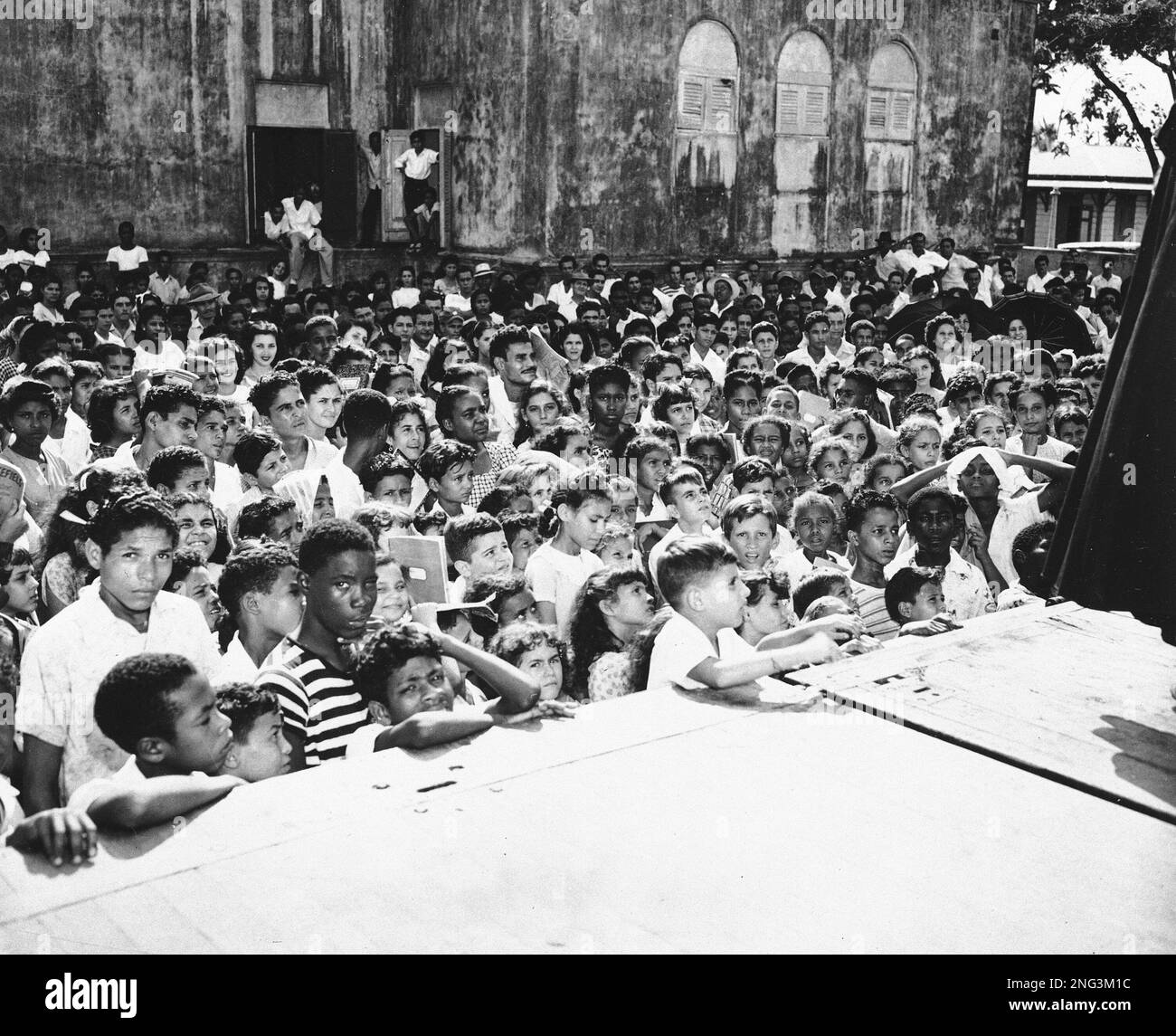 Children crowd at the edge of a stage set up in a town square in Puerto ...