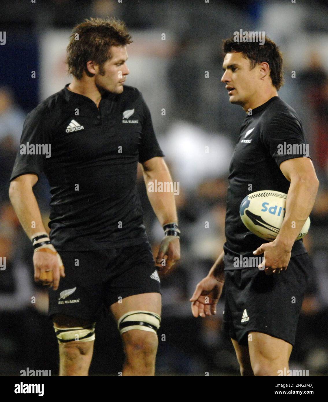 New Zealand All Black captain Richie McCaw, left talks with flyhalf ...