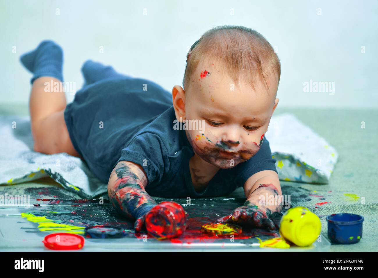 Happy baby child draws with colored paints hands. Happy child draws ...