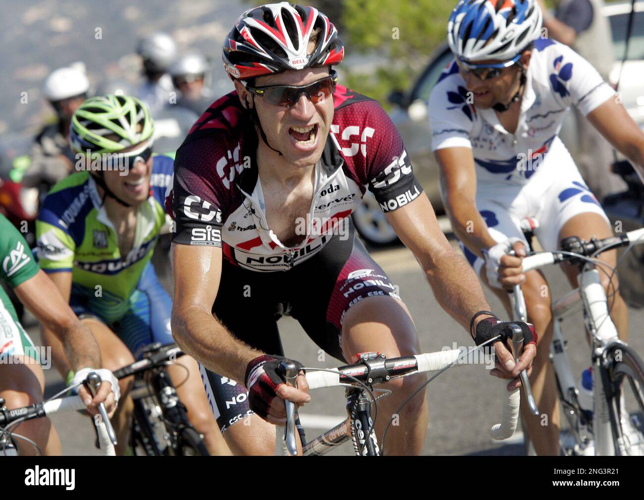 Jens Voigt of Germany, center, strains as he rides in a breakaway ...