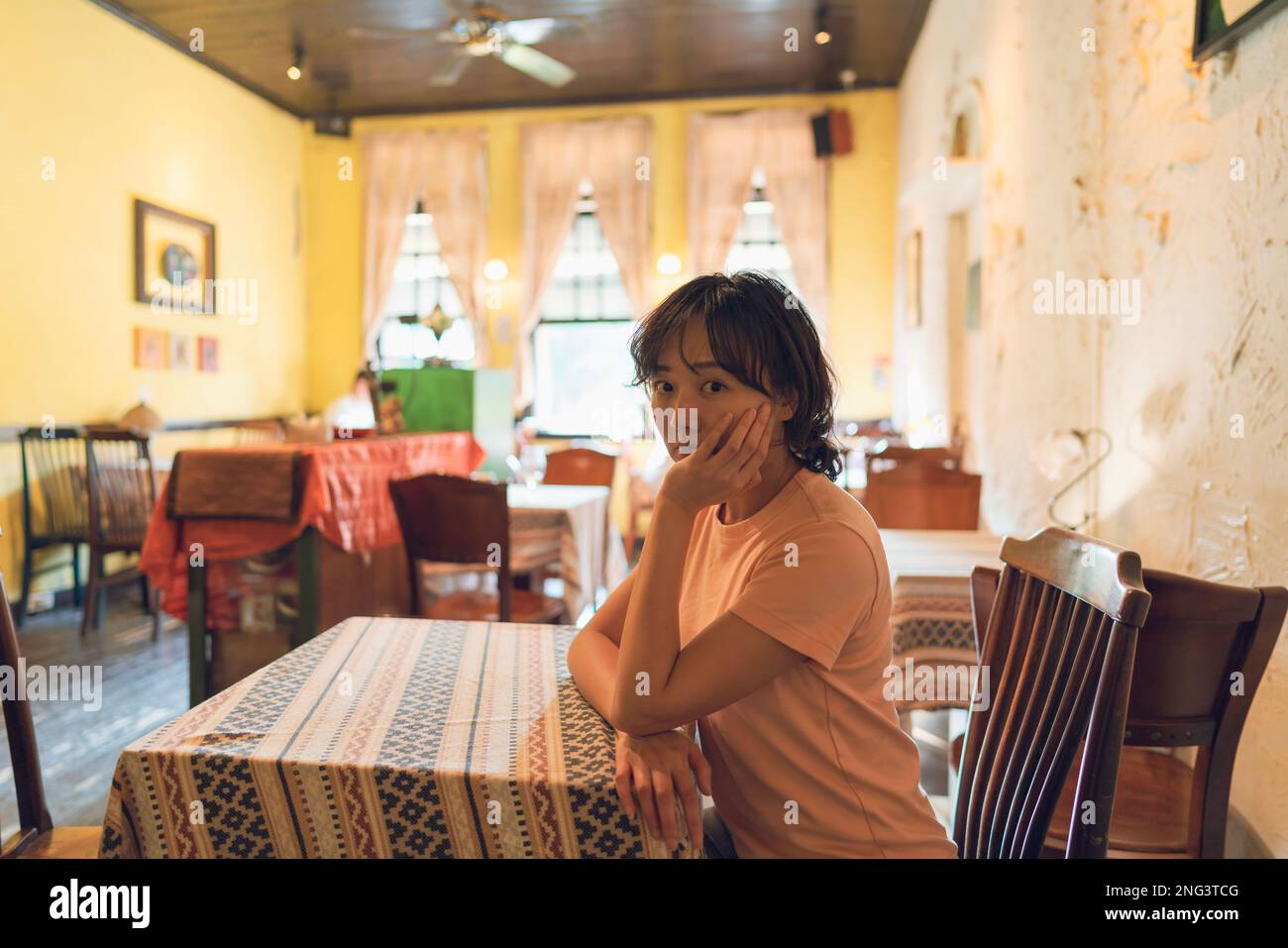 A woman sat in a vintage style cafe. The camera caught her side face ...