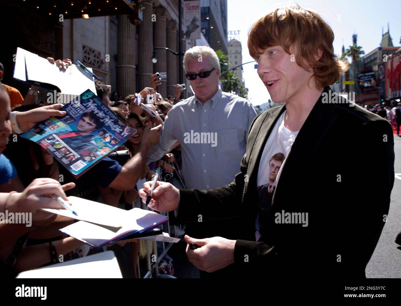 Rupert Grint signs autographs as he arrives to the premiere of "Harry ...