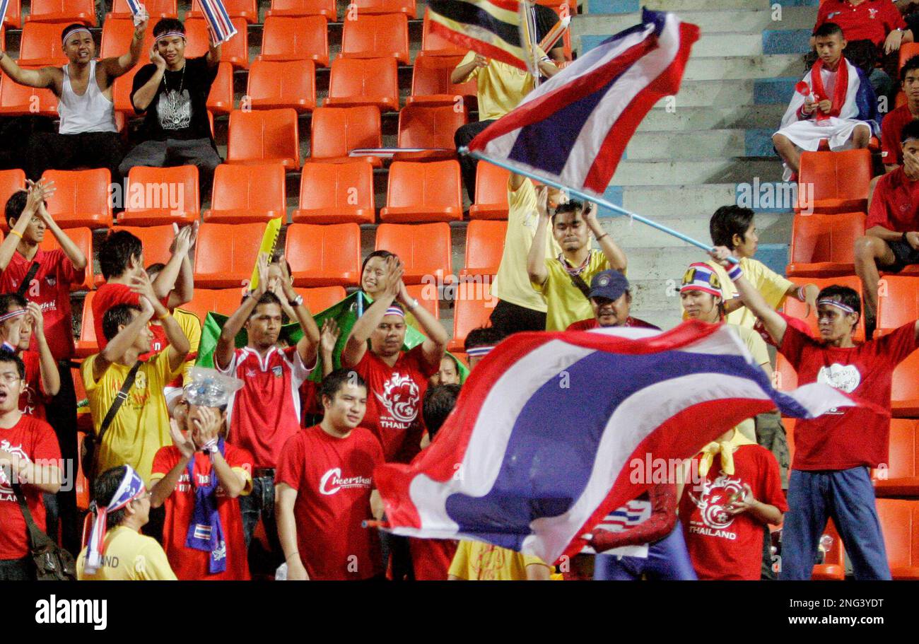 Thai fans wave flags while cheering as their team plays at the Asian ...