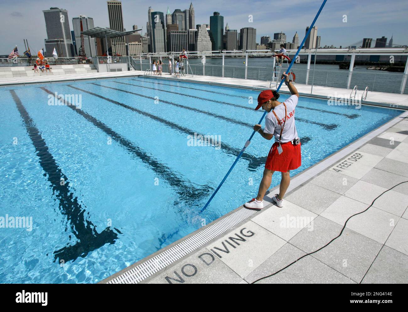 Lifeguard Vanessa Saliva cleans the water at the Floating Pool Lady, a ...