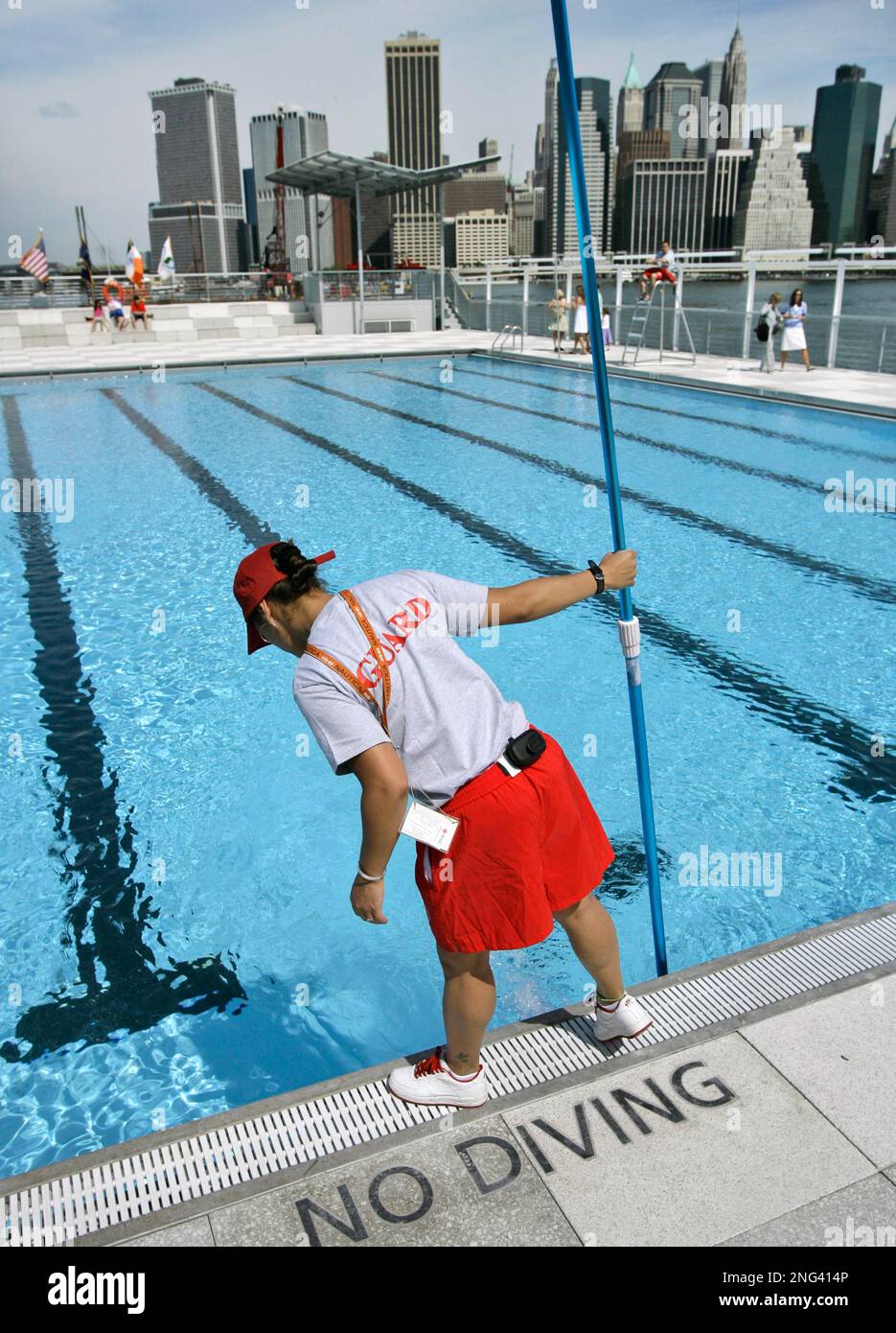 Lifeguard Vanessa Saliva cleans the water at the Floating Pool Lady, a ...