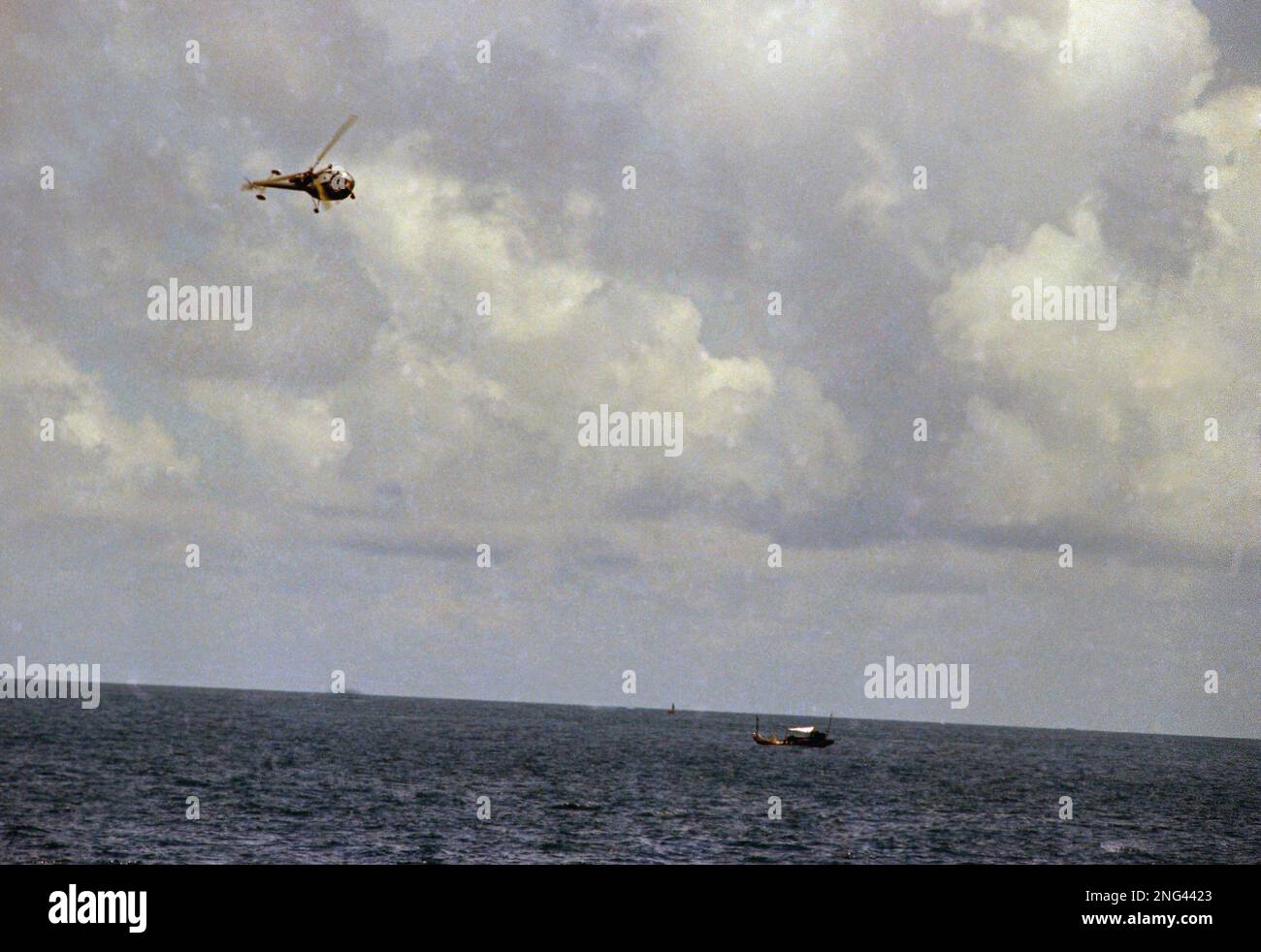 Royal Air force helicopter flies over a junk on the high seas during a ...