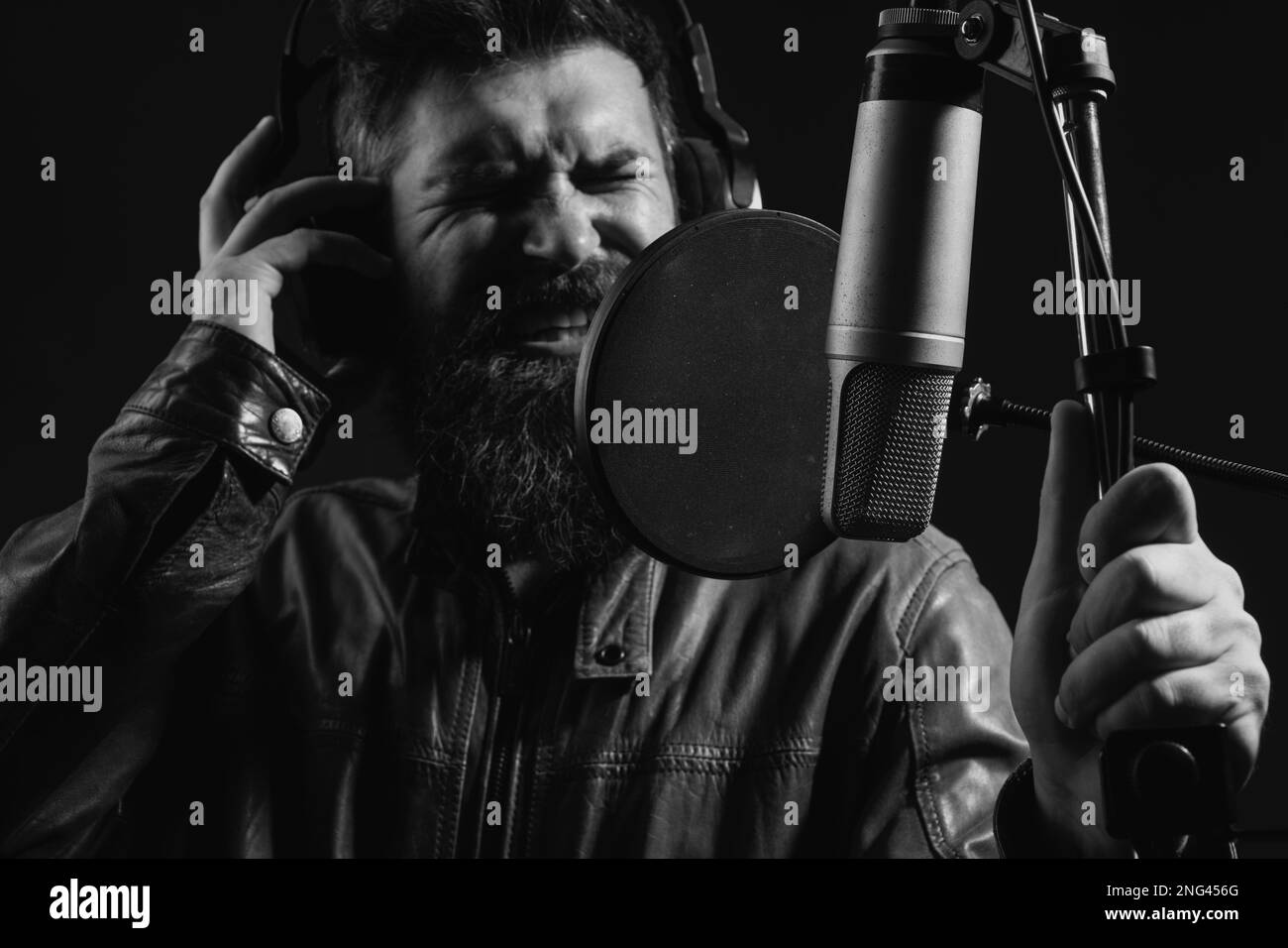 Singing man in a recording studio. Expressive bearded man with ...