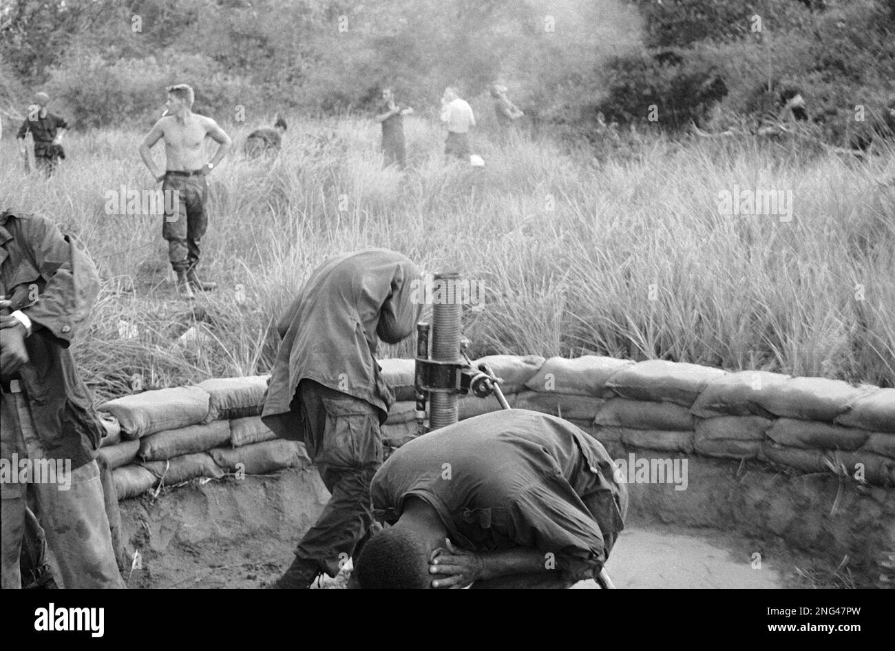 Two GIs cover their ears and faces and turn away as an 81mm mortar ...