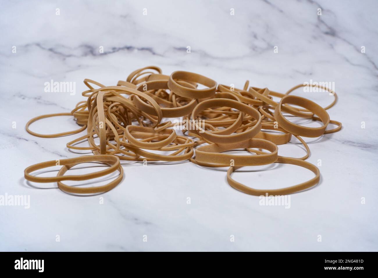 Pile of rubber bands isolated on white marble background Stock Photo ...