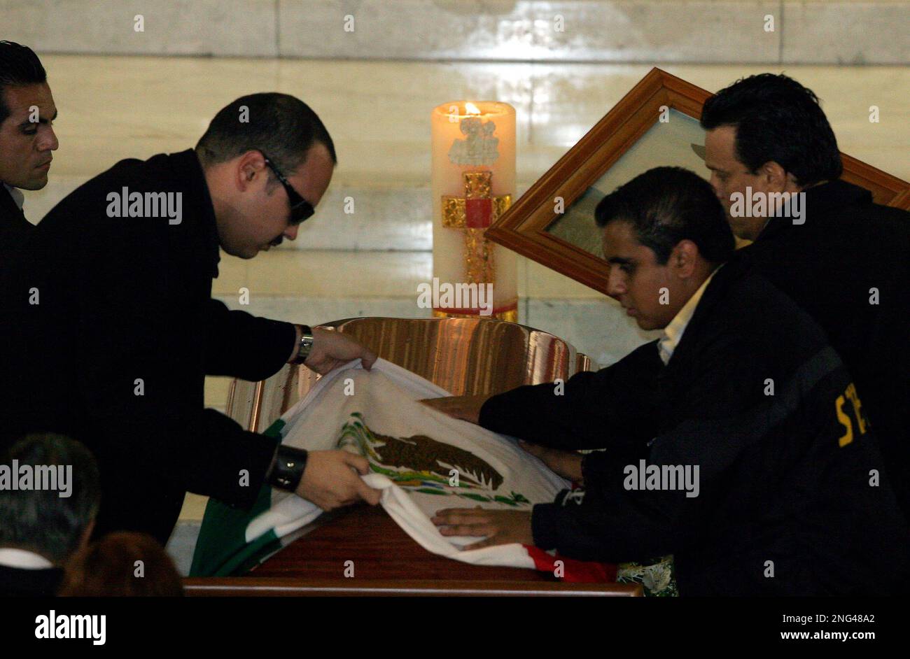 Pepe Aguilar, second from left, places a flag on the coffin of his ...