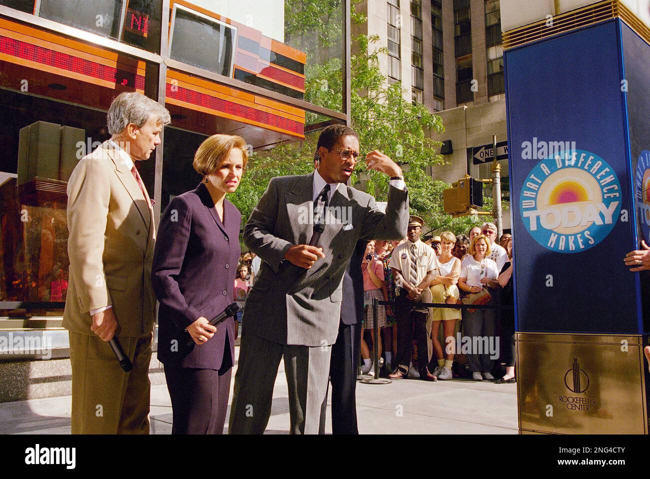 Bryant Gumbel, right, pumps up the crowd as he and co-host Katie Couric ...