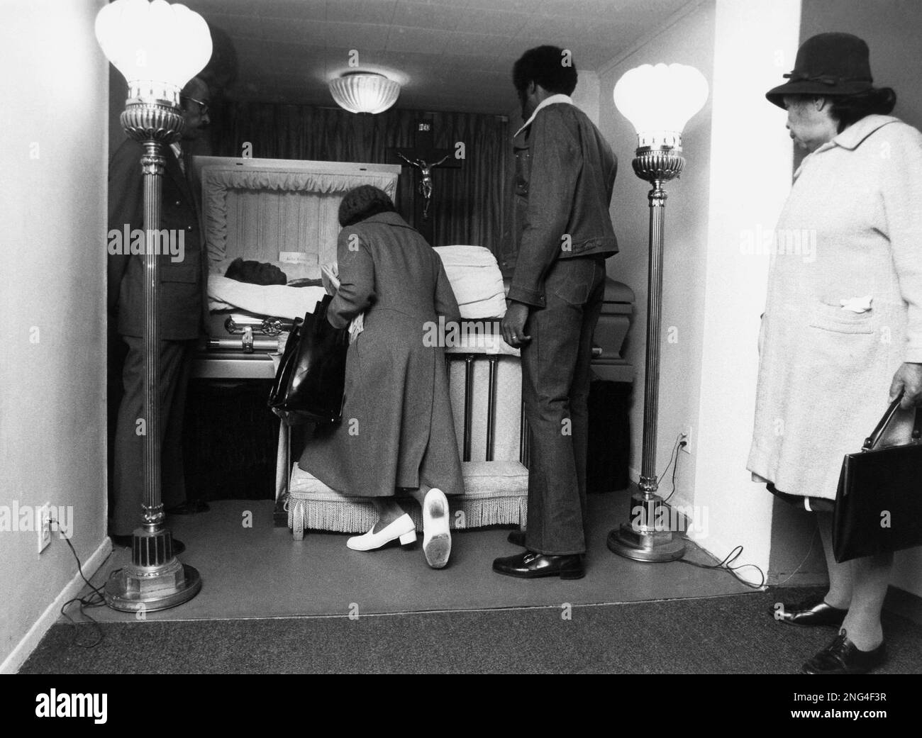 An unidentified mourner kneels by the open casket of baseball hall of ...
