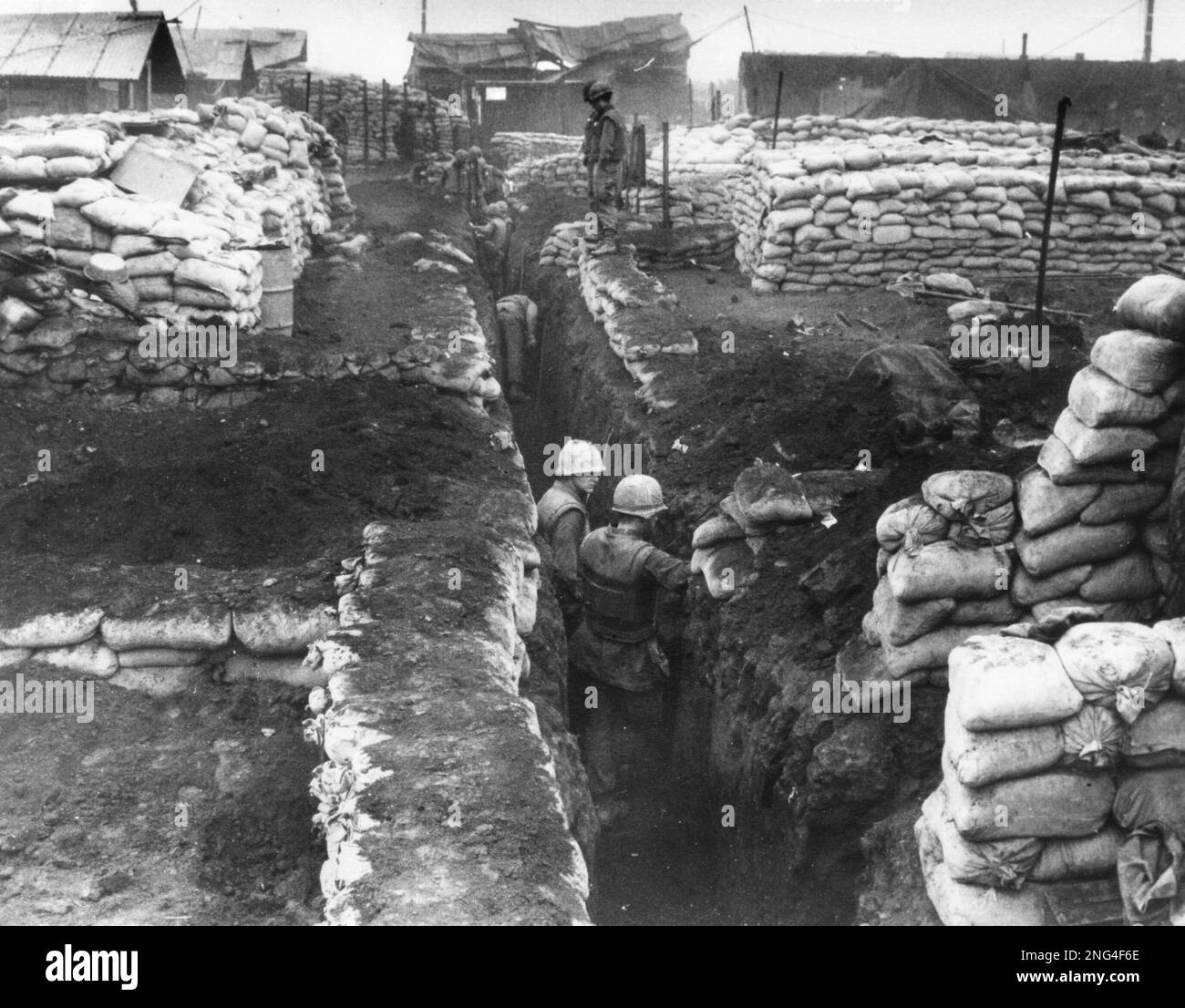U.S. Marines use the protection of deep trenches to move around their ...